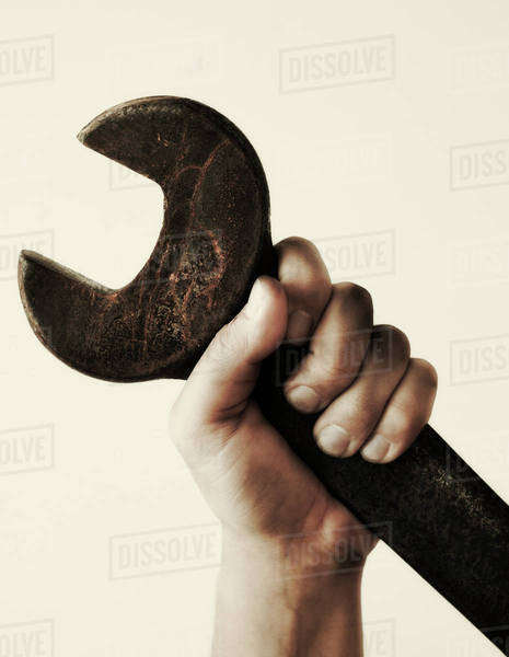 Hand holding wrench, studio shot - Royalty-free Stock Photo | Dissolve