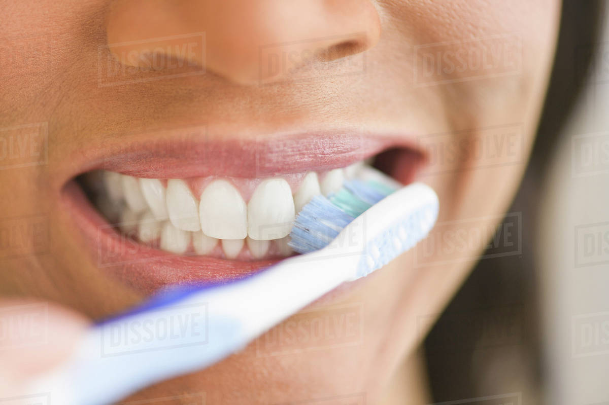 Close-up of woman brushing teeth - Stock Photo - Dissolve