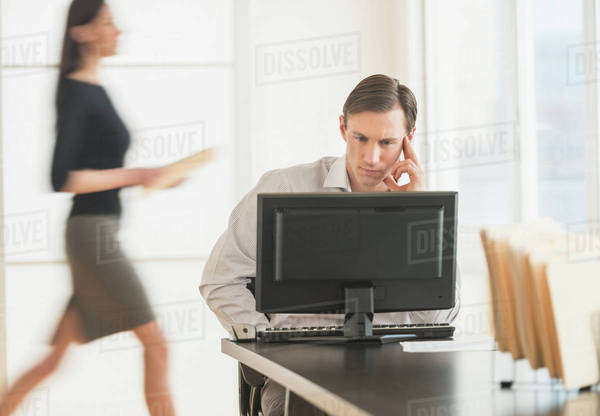 Office worker using computer - Stock Photo - Dissolve
