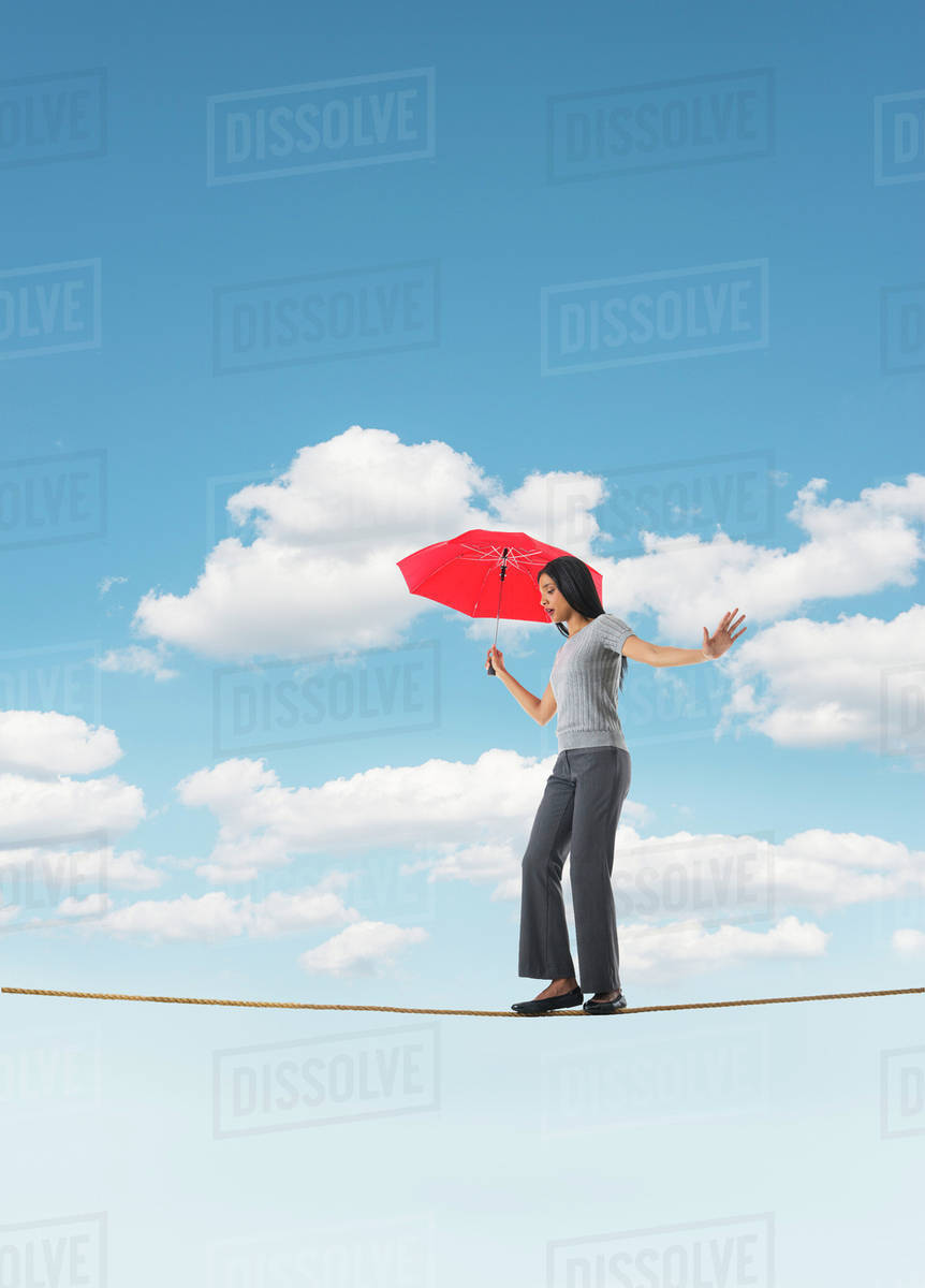 Woman balancing on tightrope - Stock Photo - Dissolve