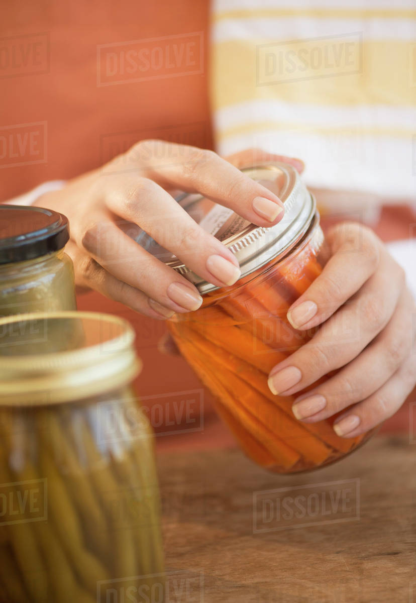 Woman closing jar with pickled vegetables - Royalty-free Stock Photo ...