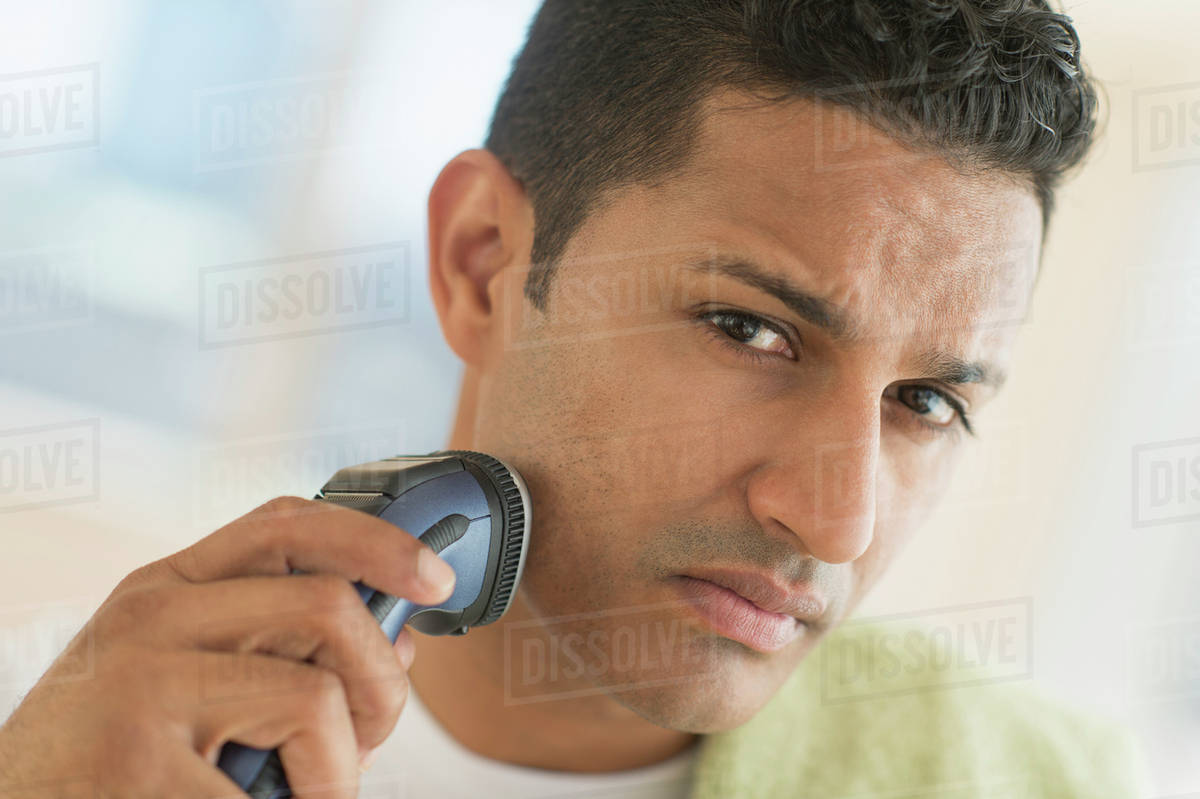Man shaving with electric razor - Stock Photo - Dissolve