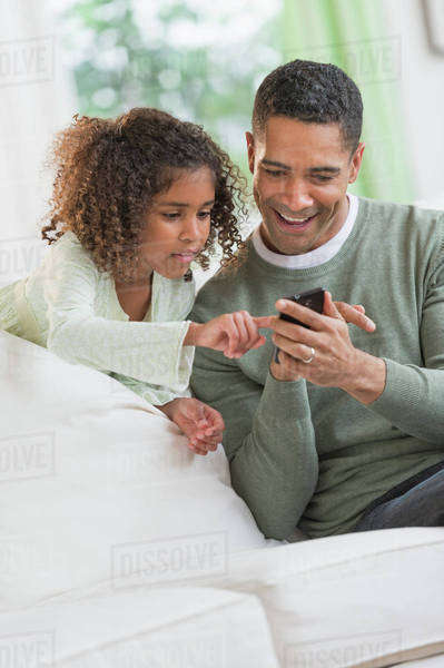Father and daughter (6-7) using mobile phone - Royalty-free Stock Photo ...