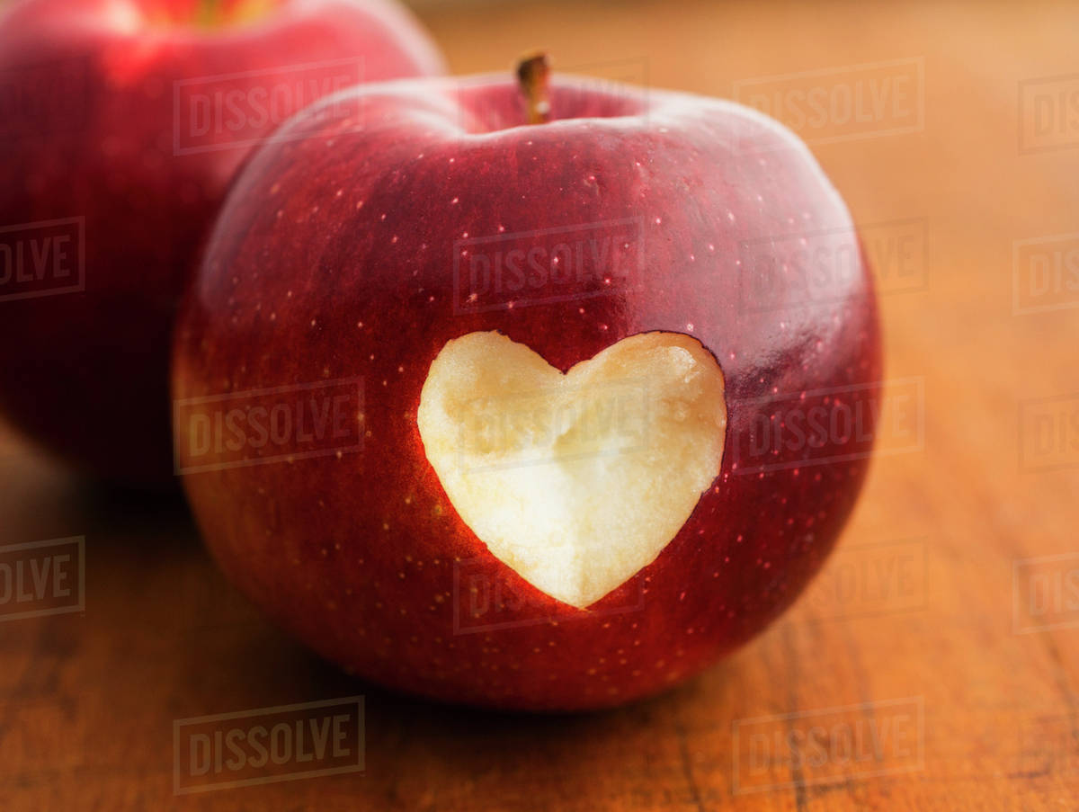 Close up of apple with missing bite in heart shape, studio shot ...