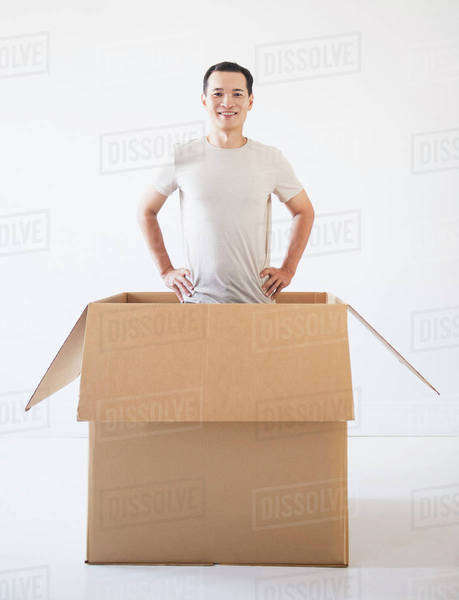 Man popping out from cardboard box - Stock Photo - Dissolve