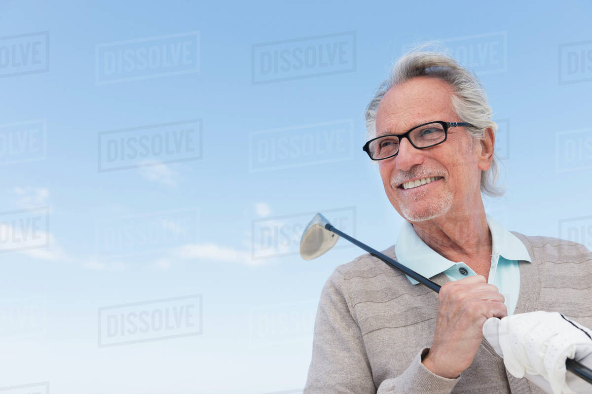 Senior man holding golf club - Stock Photo - Dissolve
