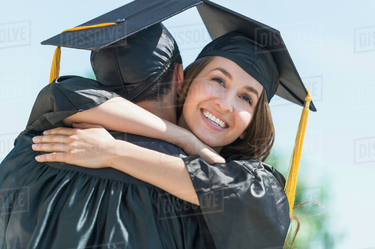 Female and male students embracing on graduation ceremony - Royalty ...