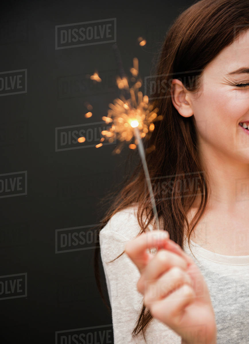 Young woman holding firework - Royalty-free Stock Photo | Dissolve