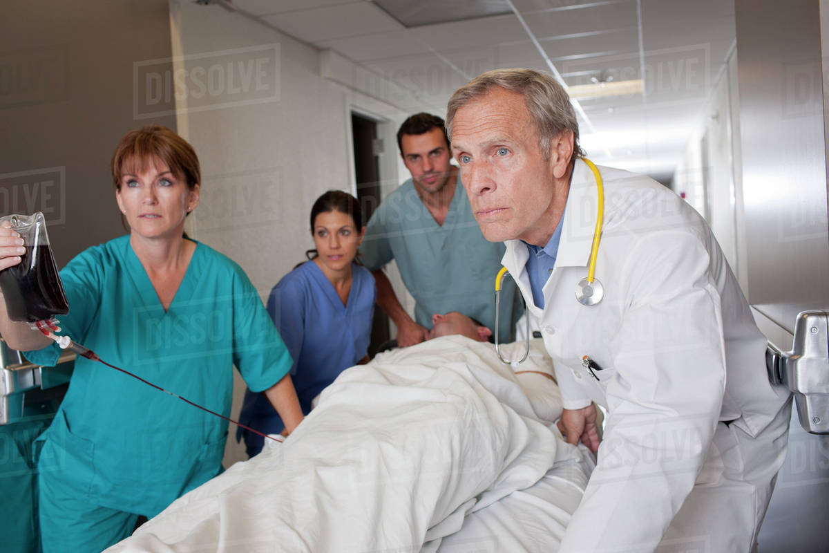 Team of doctors wheeling in patient - Royalty-free Stock Photo | Dissolve