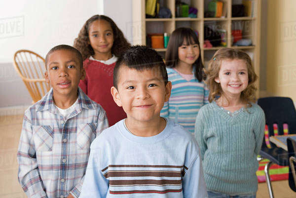 Smiling children (6-7) in classroom - Stock Photo - Dissolve