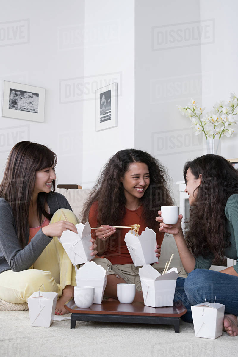 Young women eating take out food at home - Royalty-free Stock Photo ...