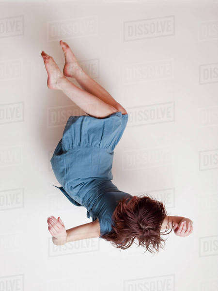 Young woman wearing blue dress falling upside down - Royalty-free Stock ...