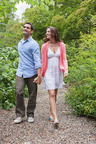 Happy couple walking through garden - Stock Photo - Dissolve