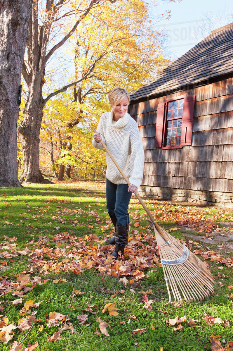 USA, New Jersey, Woman raking leaves in front of house - Stock Photo ...