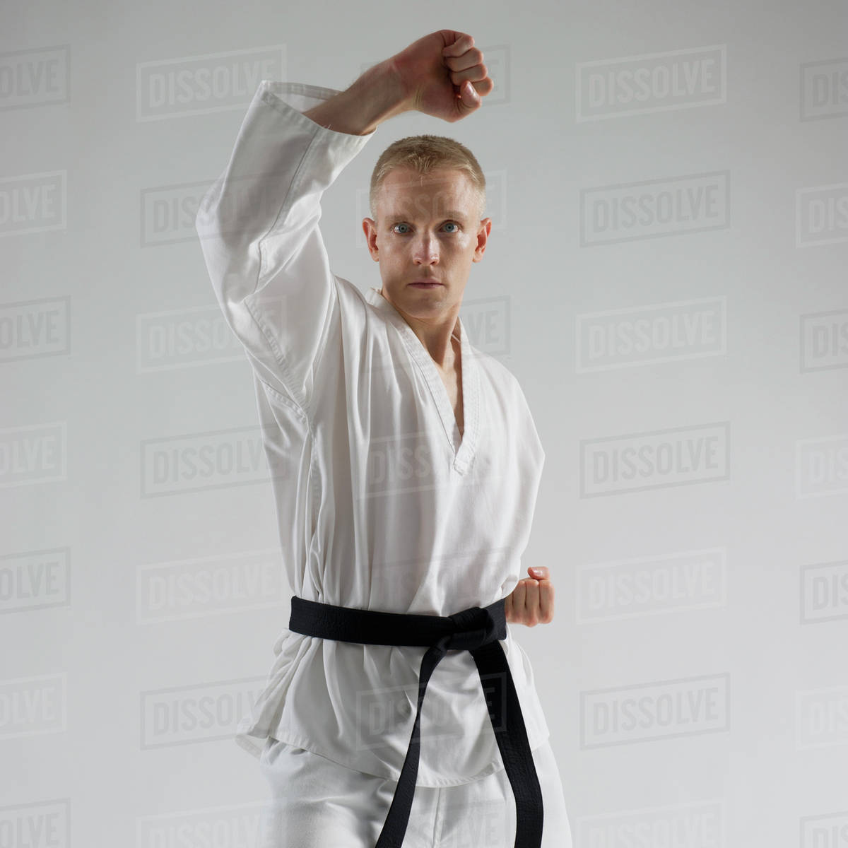 Young man performing karate stance on white background - Stock Photo ...