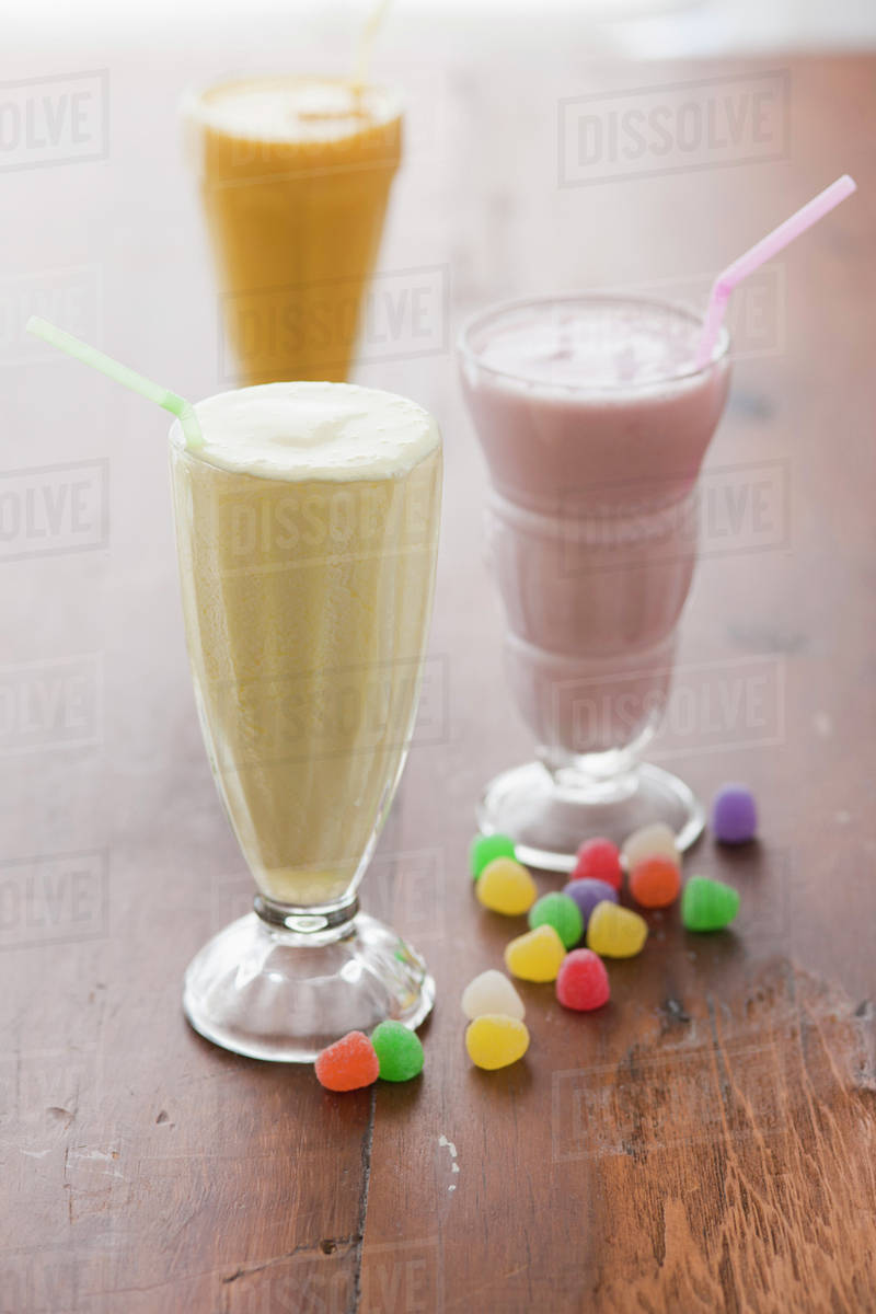 Selection of milk shakes and colorful jelly beans - Stock Photo - Dissolve