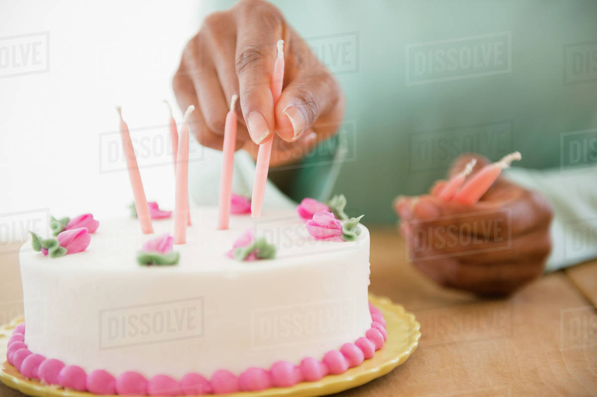 Close up of woman's hands putting candles on birthday cake - Royalty ...