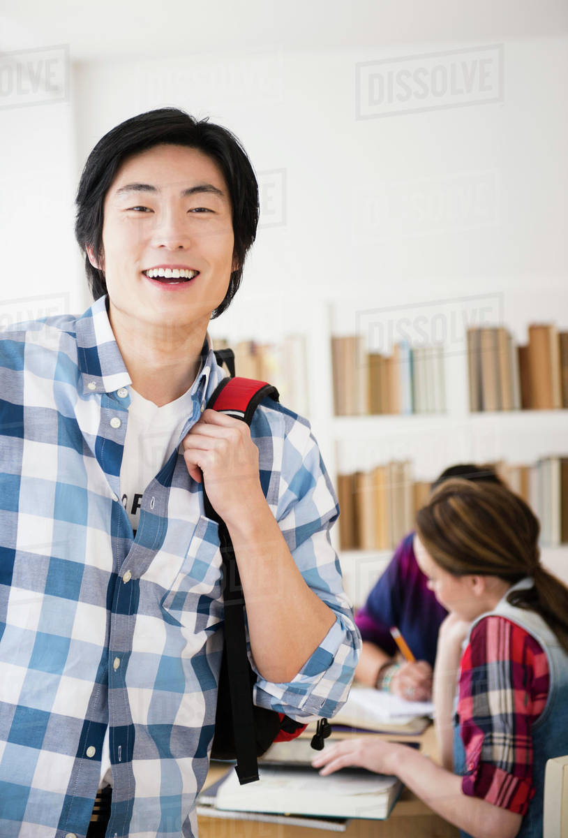 Portrait of cheerful student in library - Royalty-free Stock Photo ...