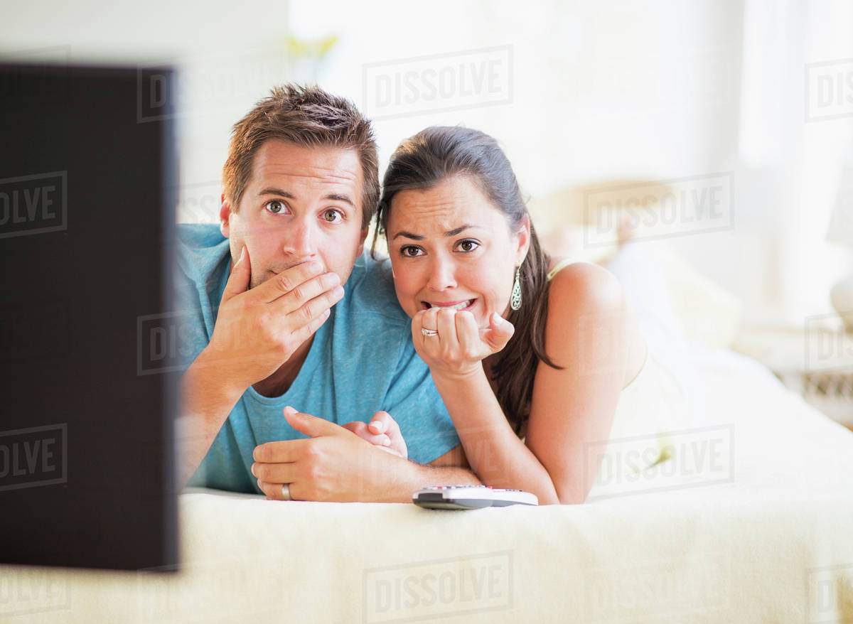 Scared couple watching TV - Royalty-free Stock Photo | Dissolve