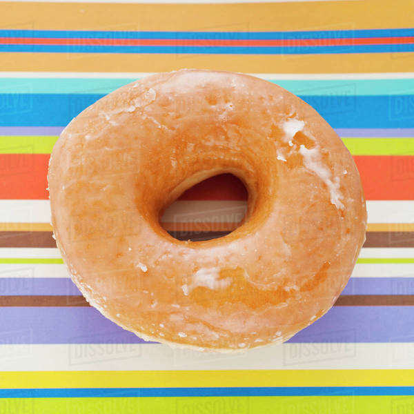 Studio shot of donut on striped background - Stock Photo - Dissolve