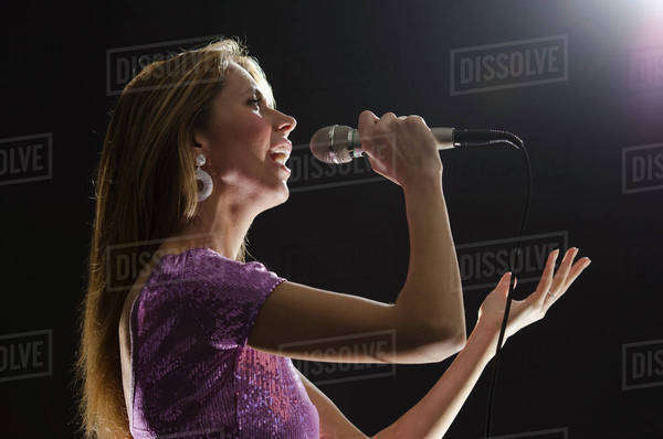 Woman singing in spotlight - Royalty-free Stock Photo | Dissolve