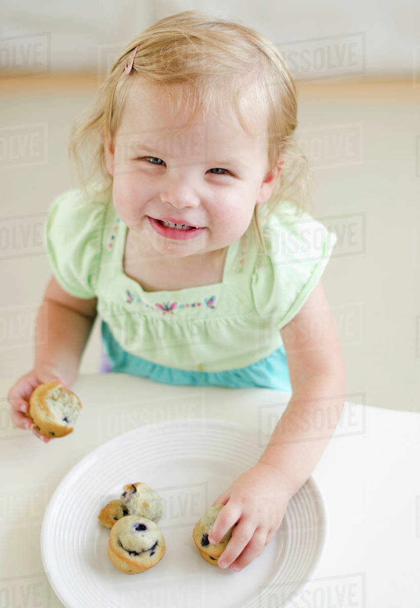 Girl (2-3) eating muffins - Royalty-free Stock Photo | Dissolve