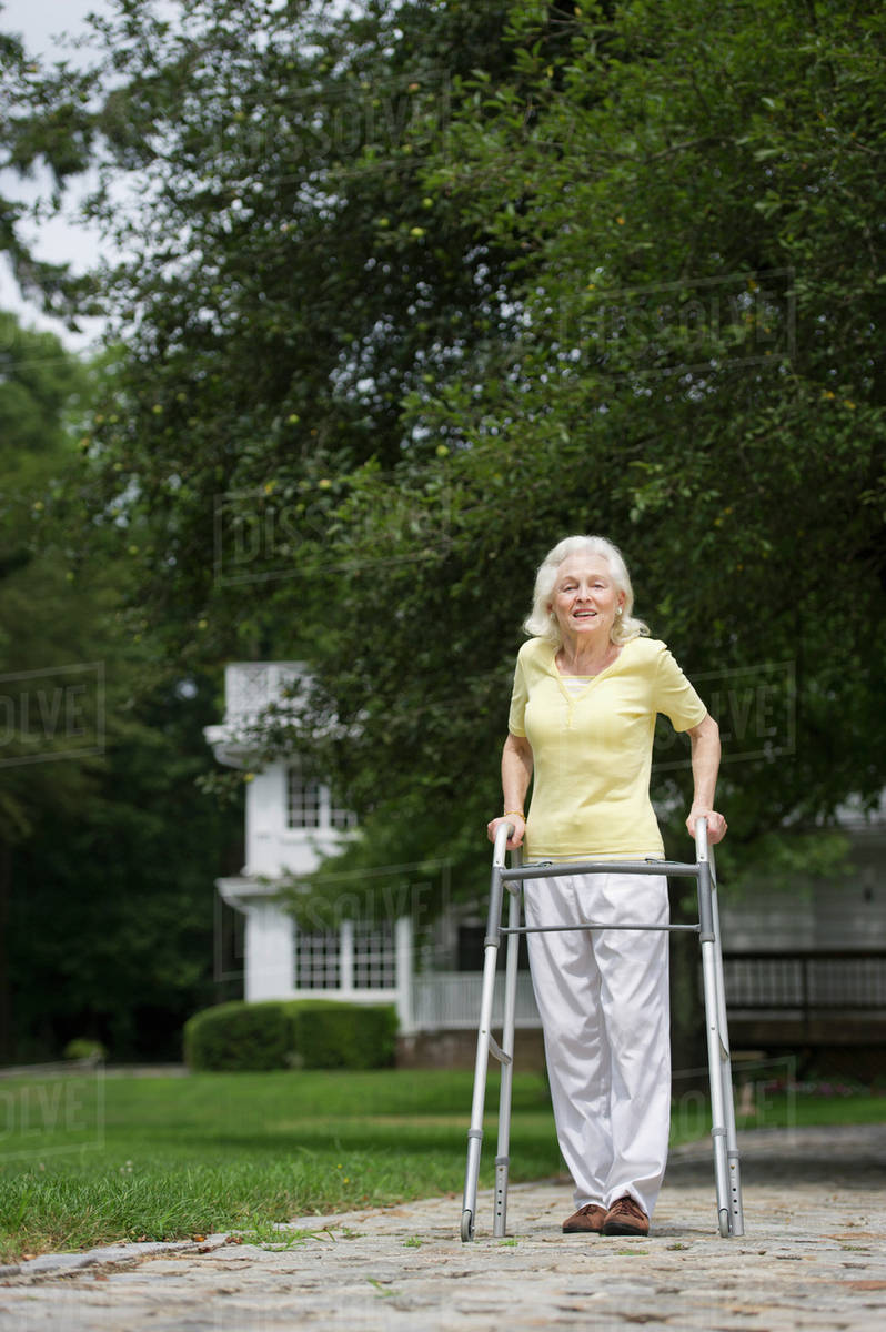 Senior woman walking with walker - Royalty-free Stock Photo | Dissolve