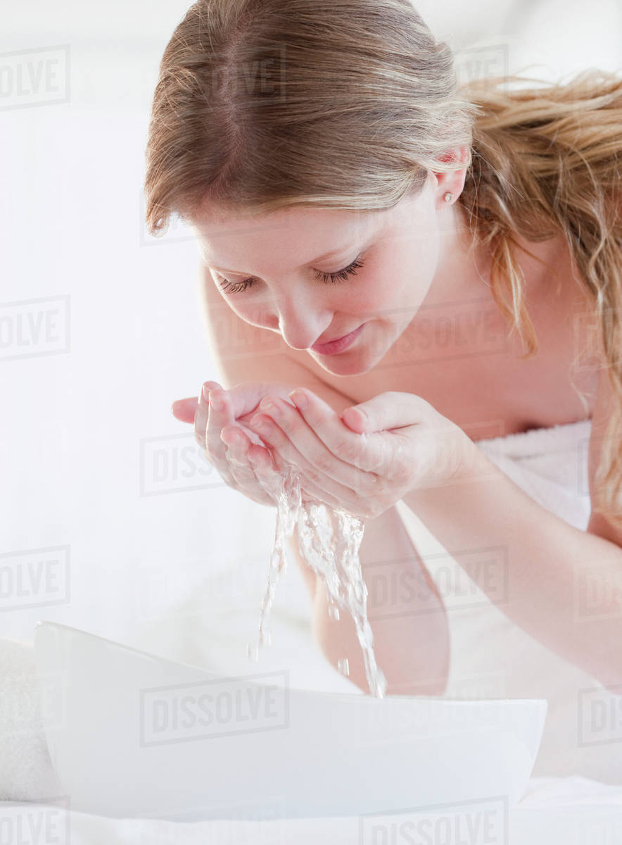 Young woman washing face - Royalty-free Stock Photo | Dissolve