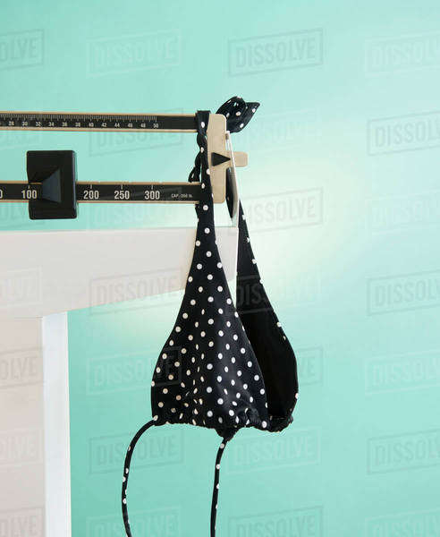 Bikini hanging on weight scale - Stock Photo - Dissolve