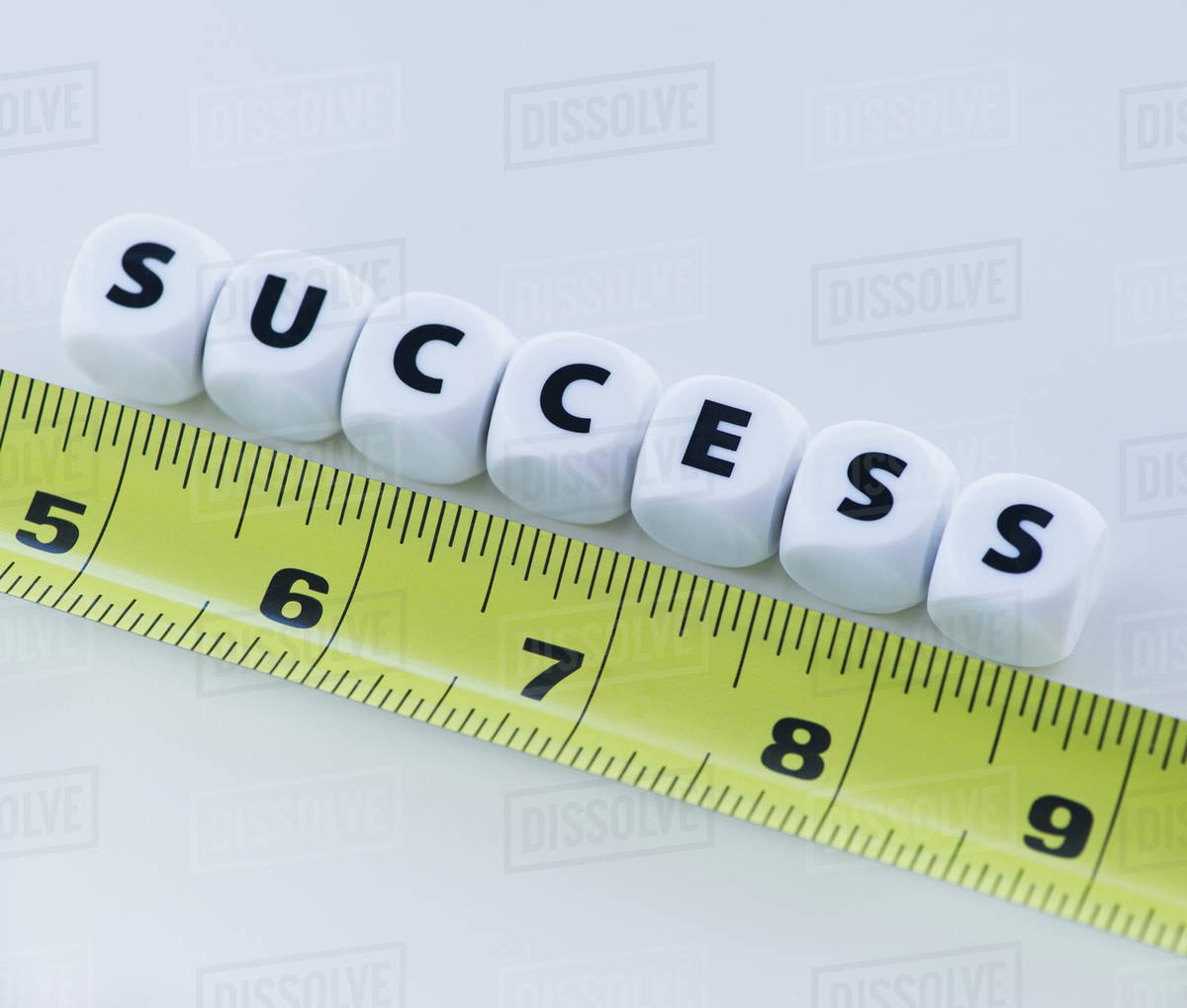 Studio shot of tape measure and dice spelling out success - Royalty ...