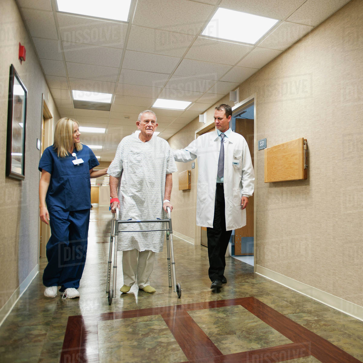 Senior man in hospital walking with walker - Stock Photo - Dissolve