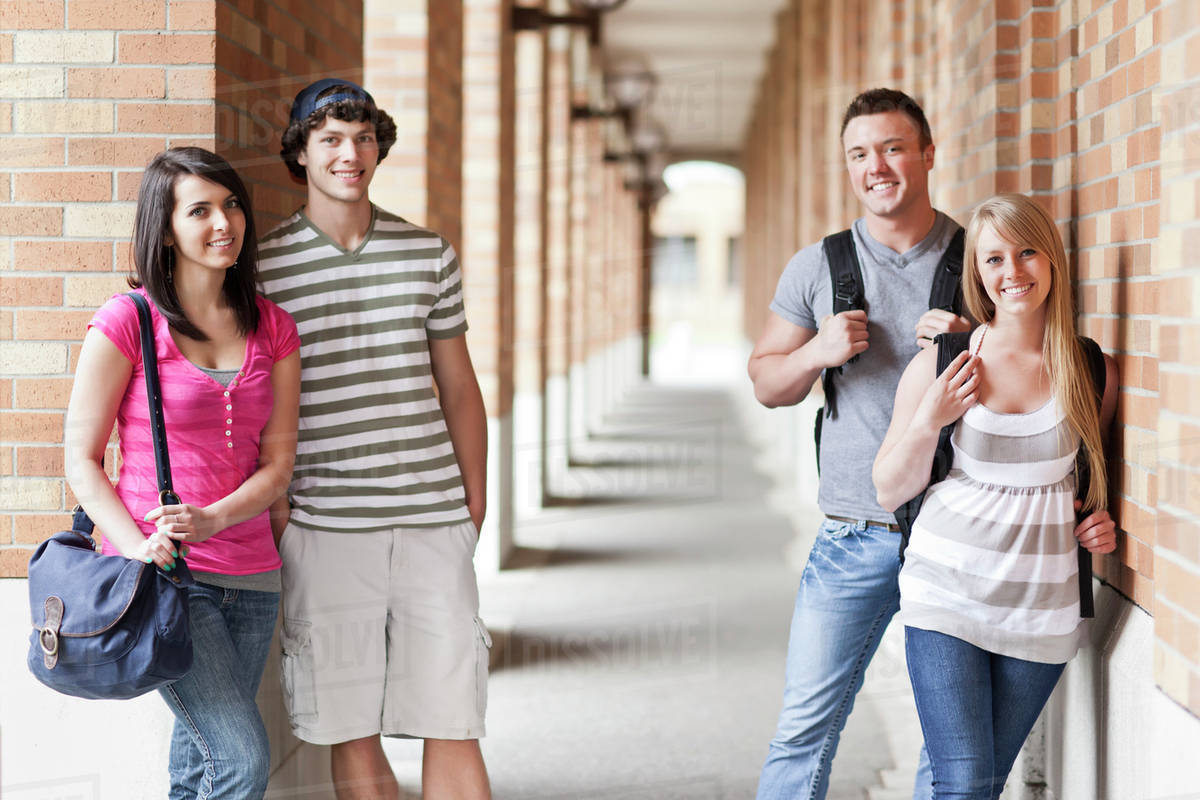 Portrait of four college students in corridor - Stock Photo - Dissolve