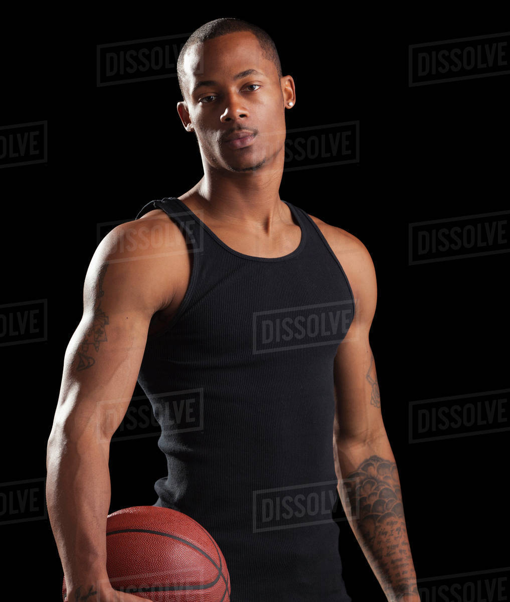 Studio portrait of young man with basketball - Royalty-free Stock Photo ...