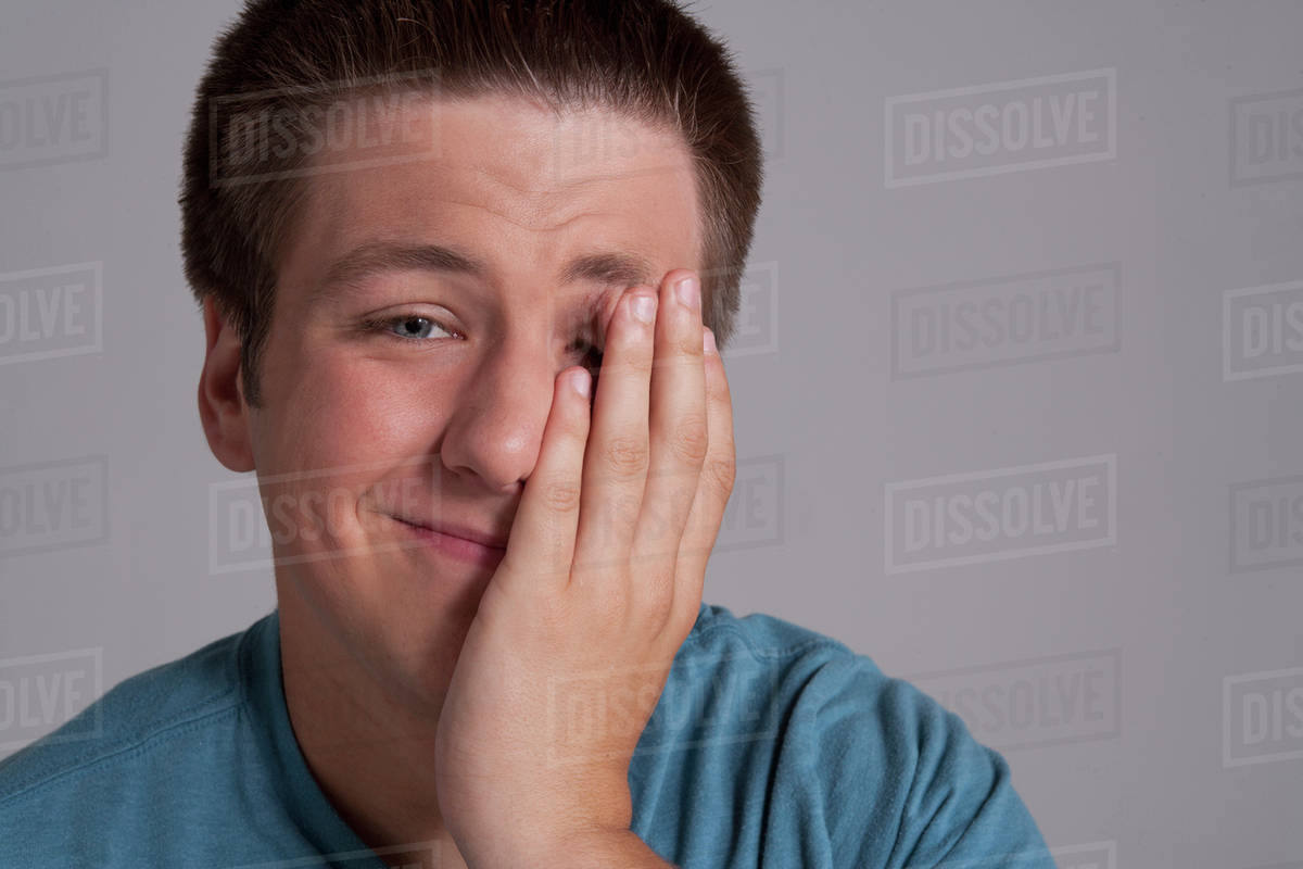Portrait of sleepy teenager, studio shot - Stock Photo - Dissolve