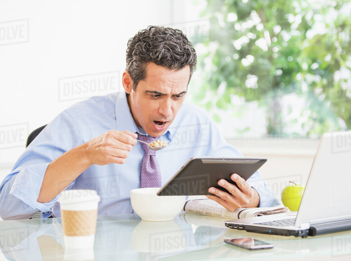 Portrait of man eating and using digital tablet - Royalty-free Stock ...