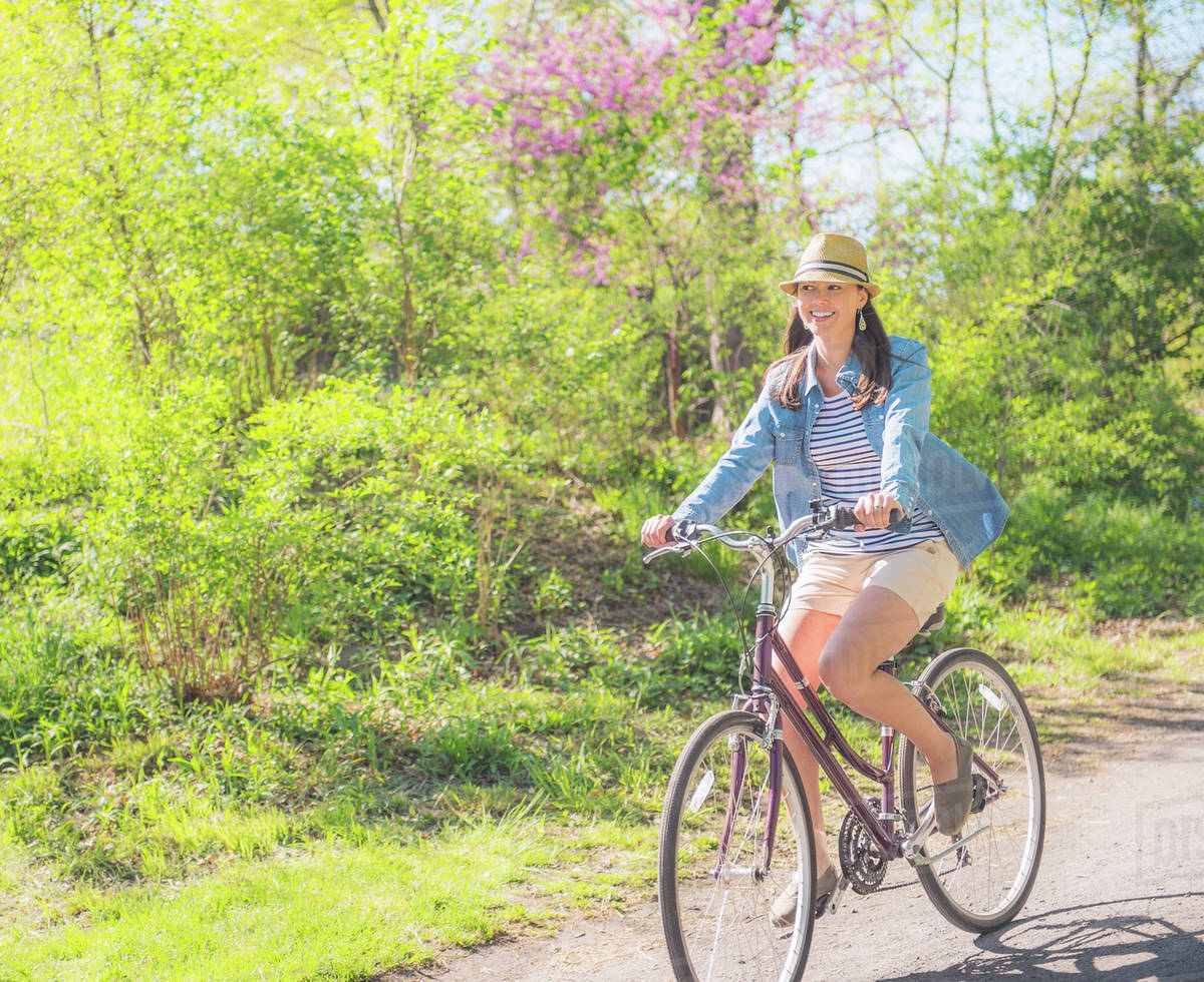 Mid adult woman riding bicycle - Stock Photo - Dissolve