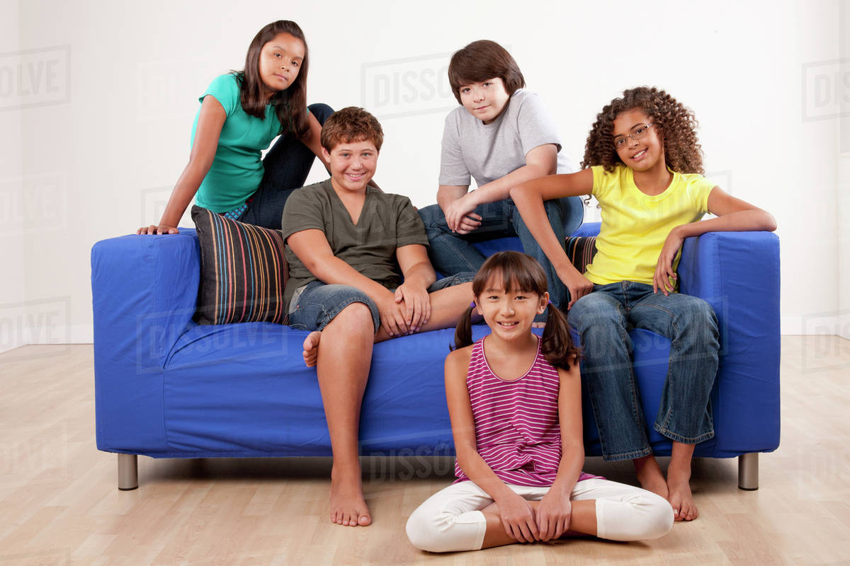 Group of children (10-11, 12-13) sitting on sofa, studio shot - Royalty ...