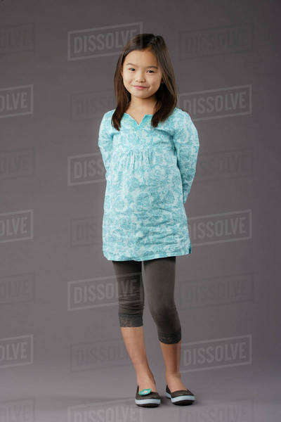 Portrait of smiling girl (8-9), studio shot - Stock Photo - Dissolve