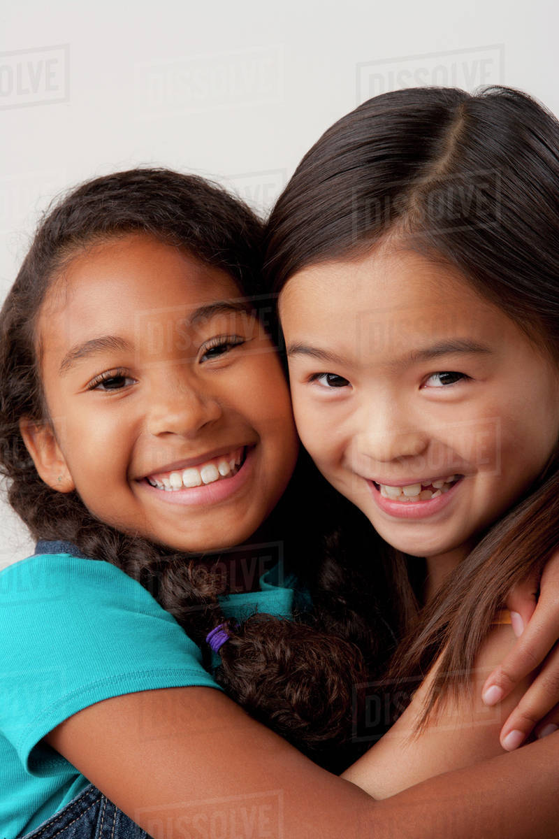 Studio portrait of two girls (8-9) embracing - Royalty-free Stock Photo ...