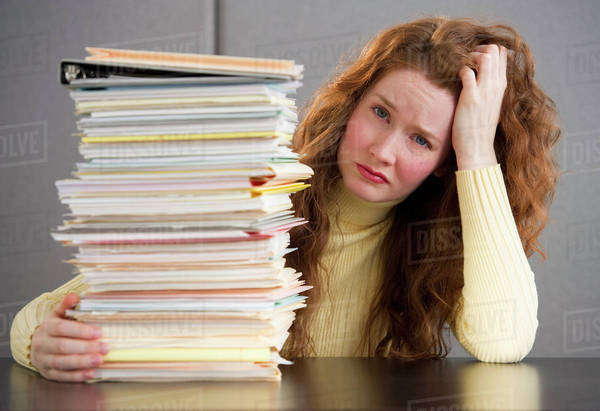 Overworked woman in cubicle - Stock Photo - Dissolve