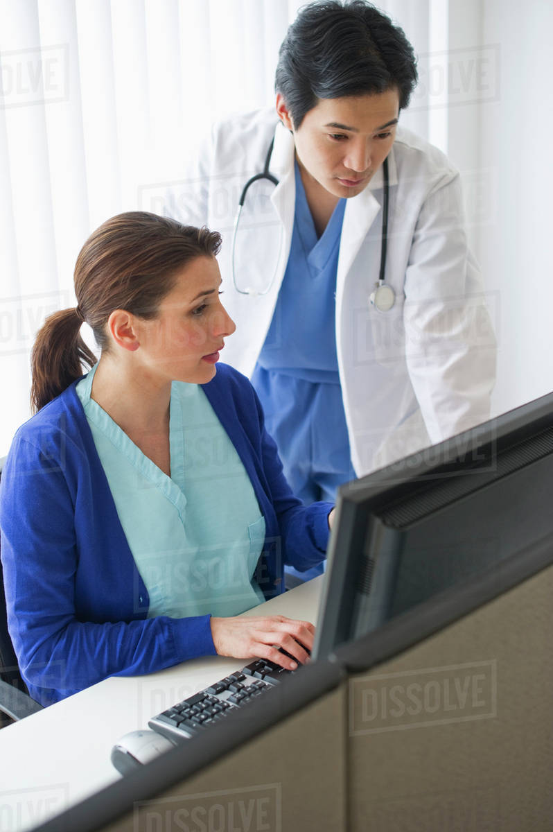 Doctor and nurse looking at computer - Stock Photo - Dissolve