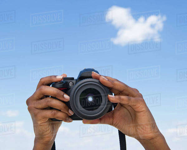 Hands holding a digital camera - Stock Photo - Dissolve