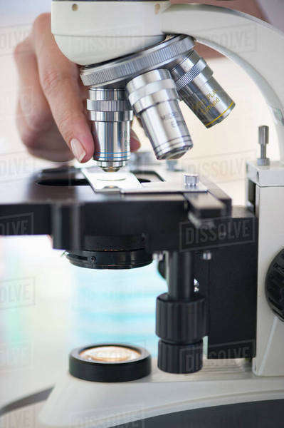 Hands on a microscope - Royalty-free Stock Photo | Dissolve