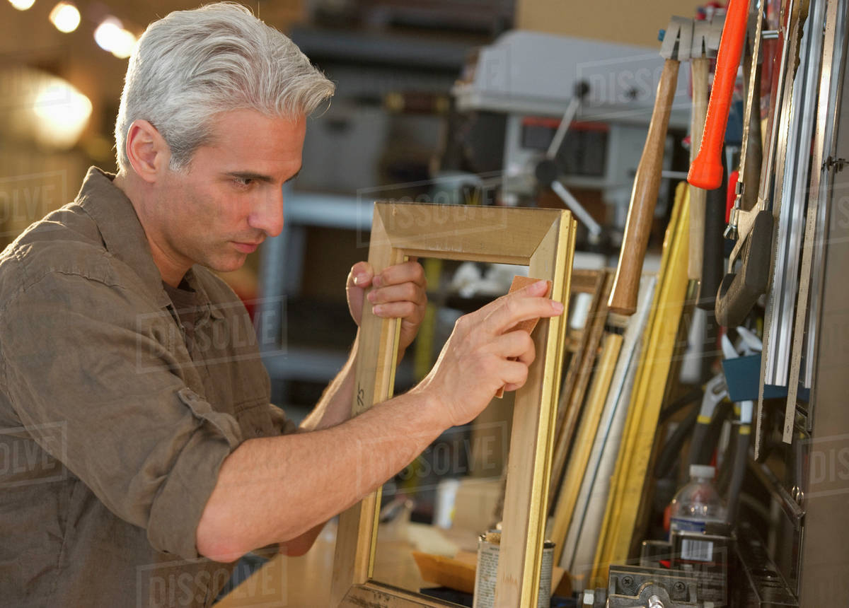 Craftsman making a picture frame - Stock Photo - Dissolve