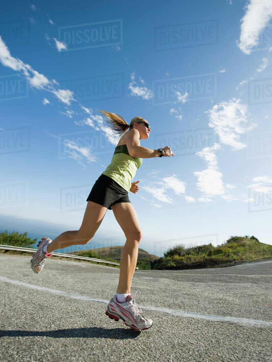 Woman running on a road in Malibu - Royalty-free Stock Photo | Dissolve