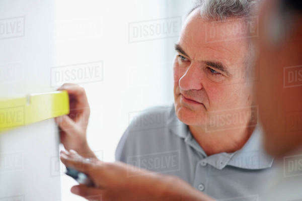 Men measuring wall - Royalty-free Stock Photo | Dissolve