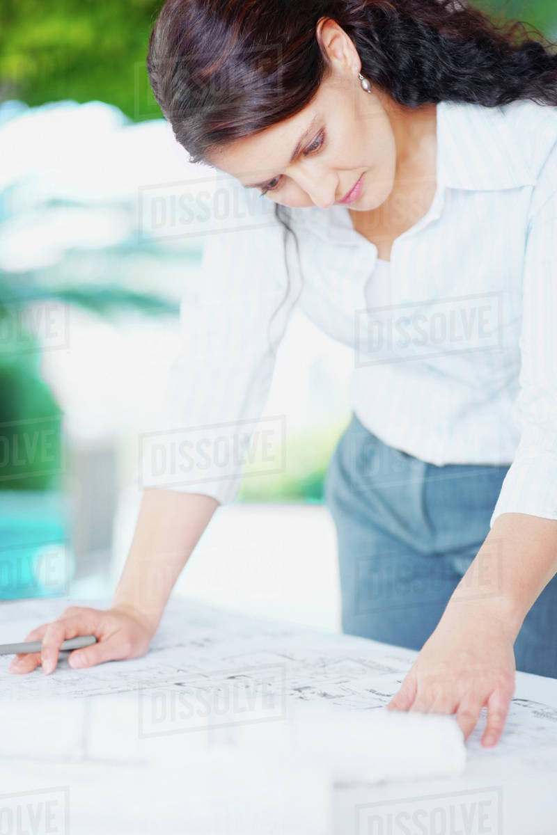 Woman looking at blueprints - Royalty-free Stock Photo | Dissolve