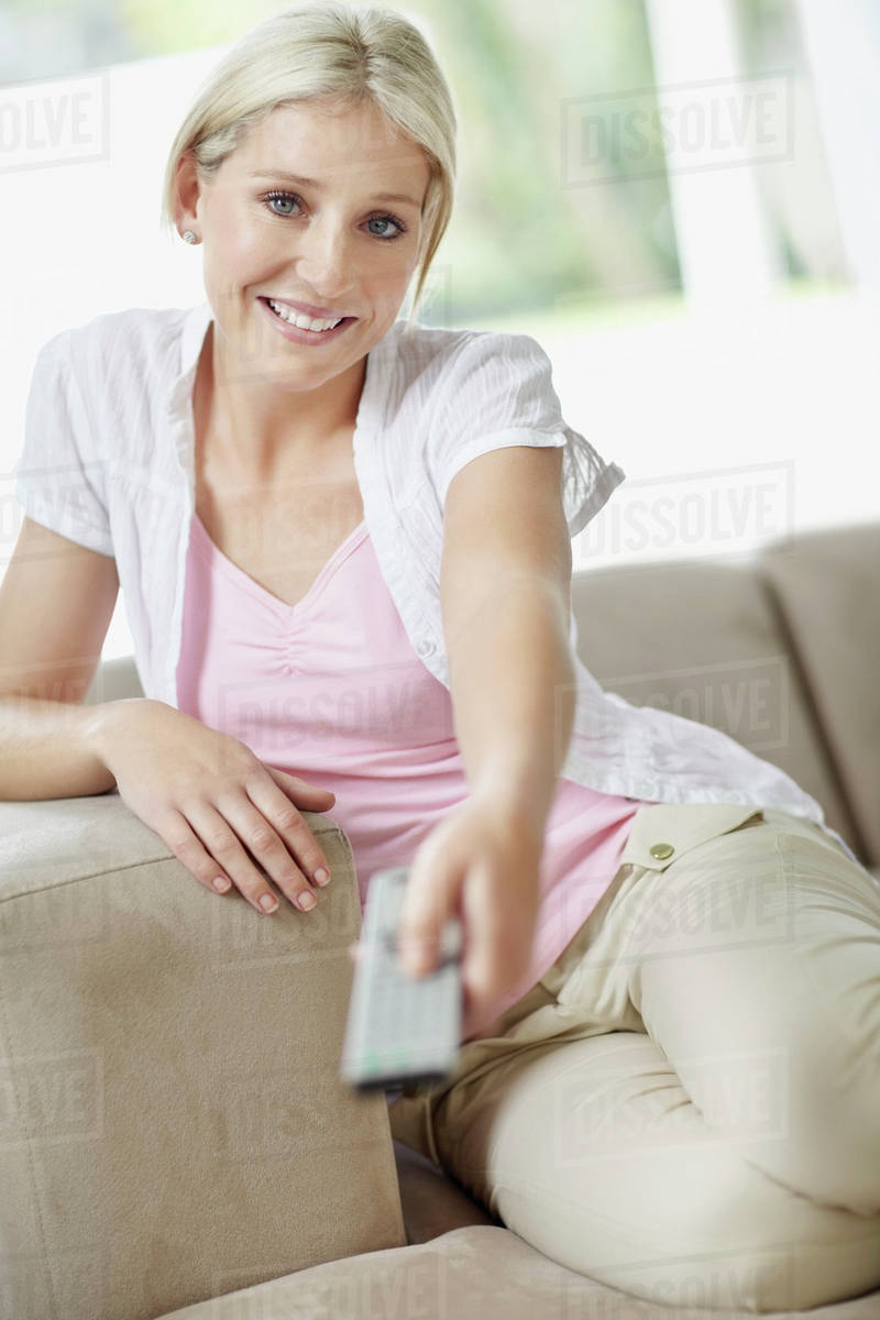 Pretty blond woman watching TV. - Royalty-free Stock Photo | Dissolve