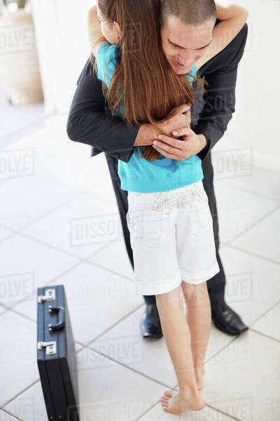 Father coming back from work embracing daughter (10-11) - Royalty-free ...