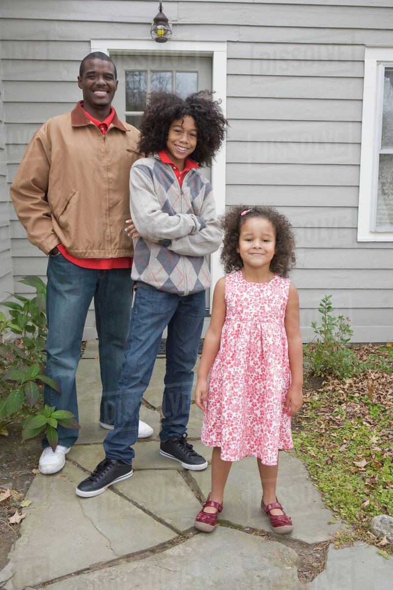 Family standing in front of house - Royalty-free Stock Photo | Dissolve